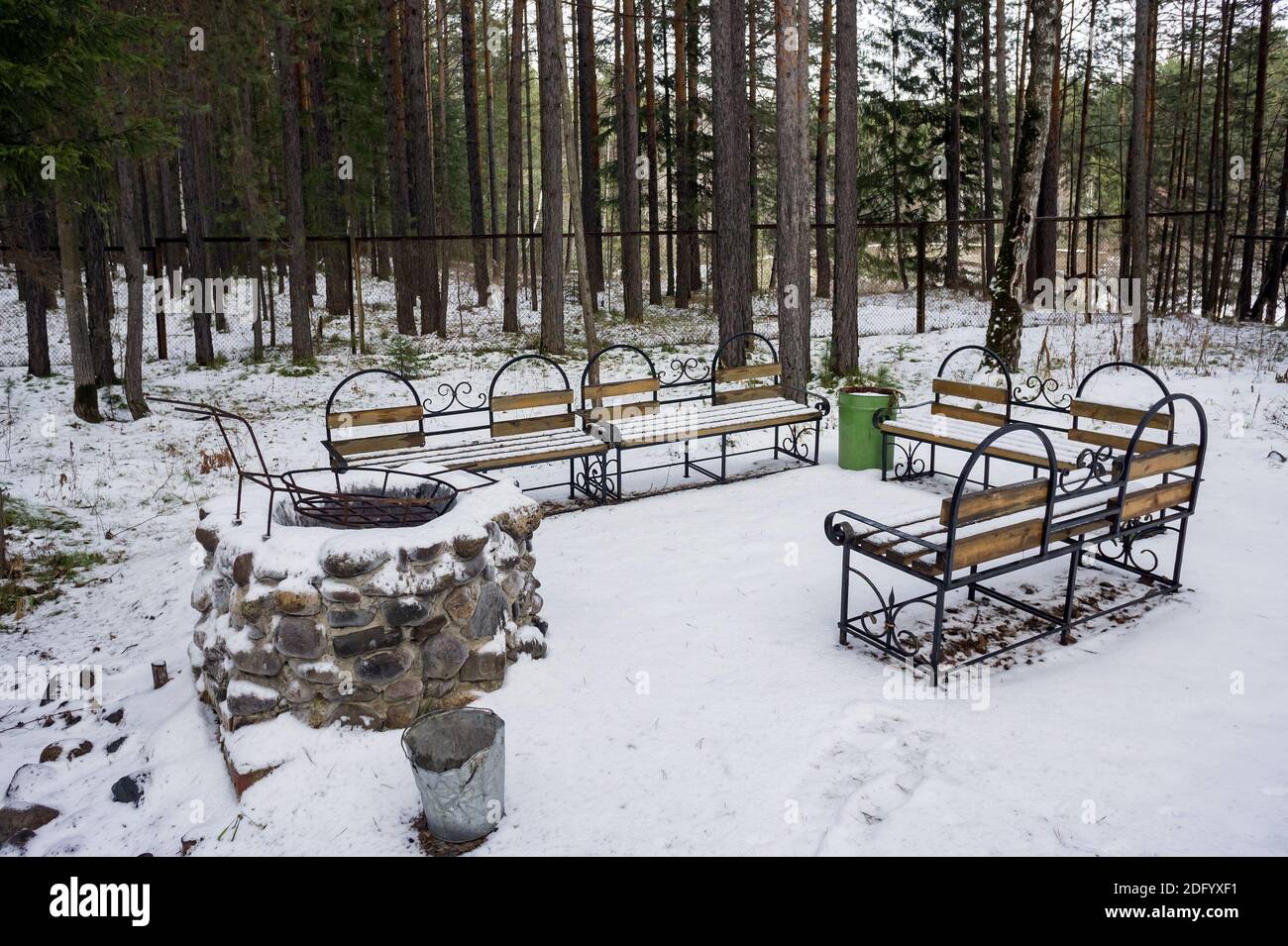 An equipped place to relax in a pine forest, with a stone stove and ...