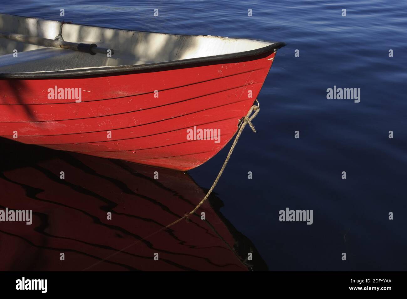 Red Dinghy in blue water Stock Photo - Alamy