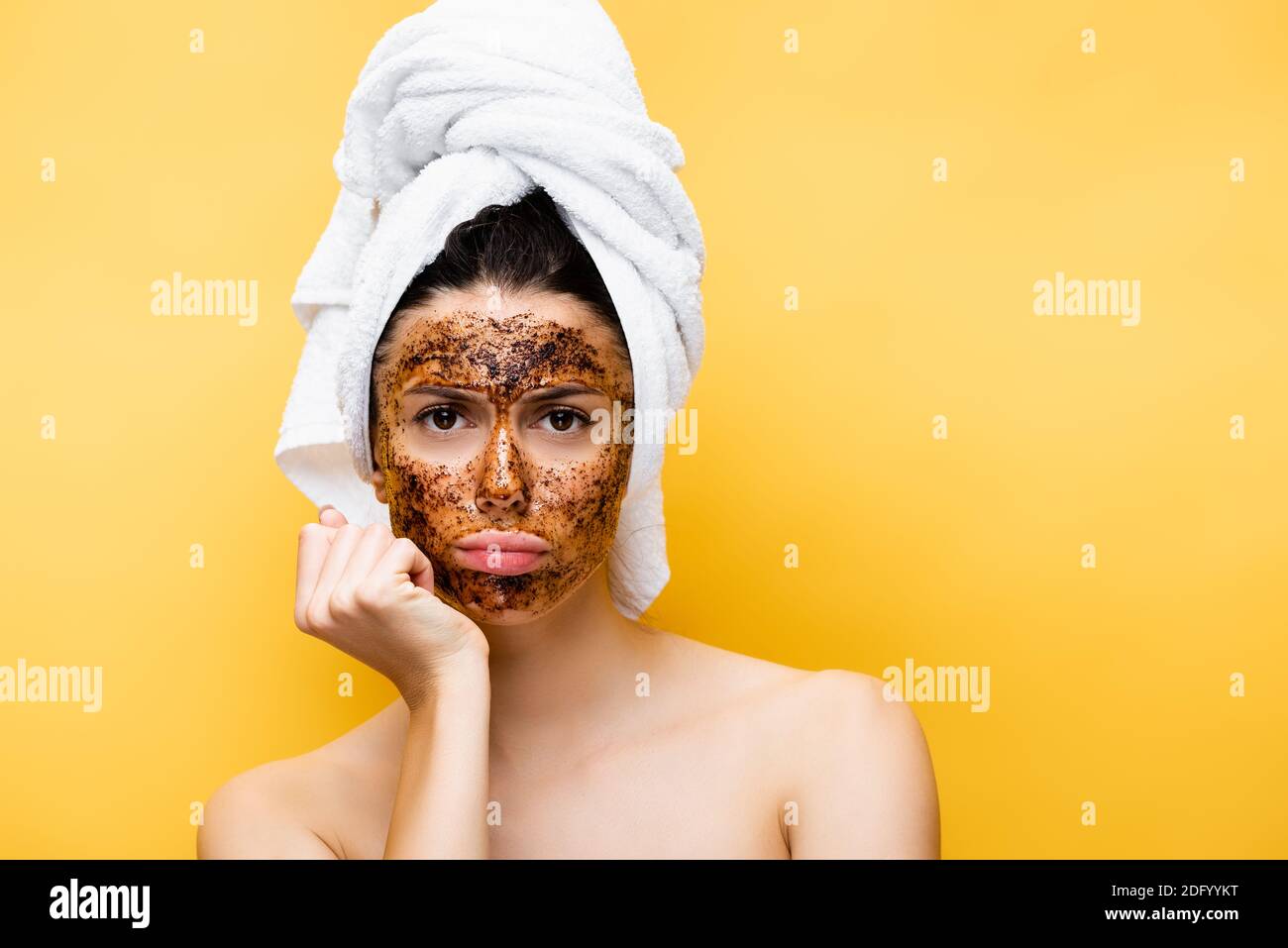 sad beautiful woman with towel on head and coffee mask on face isolated ...