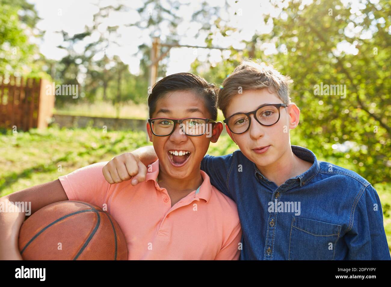 Happy multicultural kids as friends with basketball at summer camp in ...