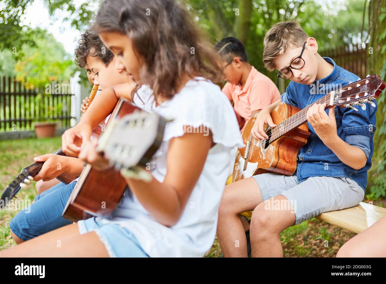 Group of children in the guitar class practices playing the guitar for ...