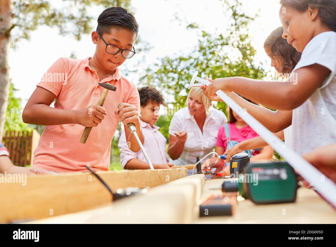 Child with chisel tool in summer workshop while chiseling wood Stock ...