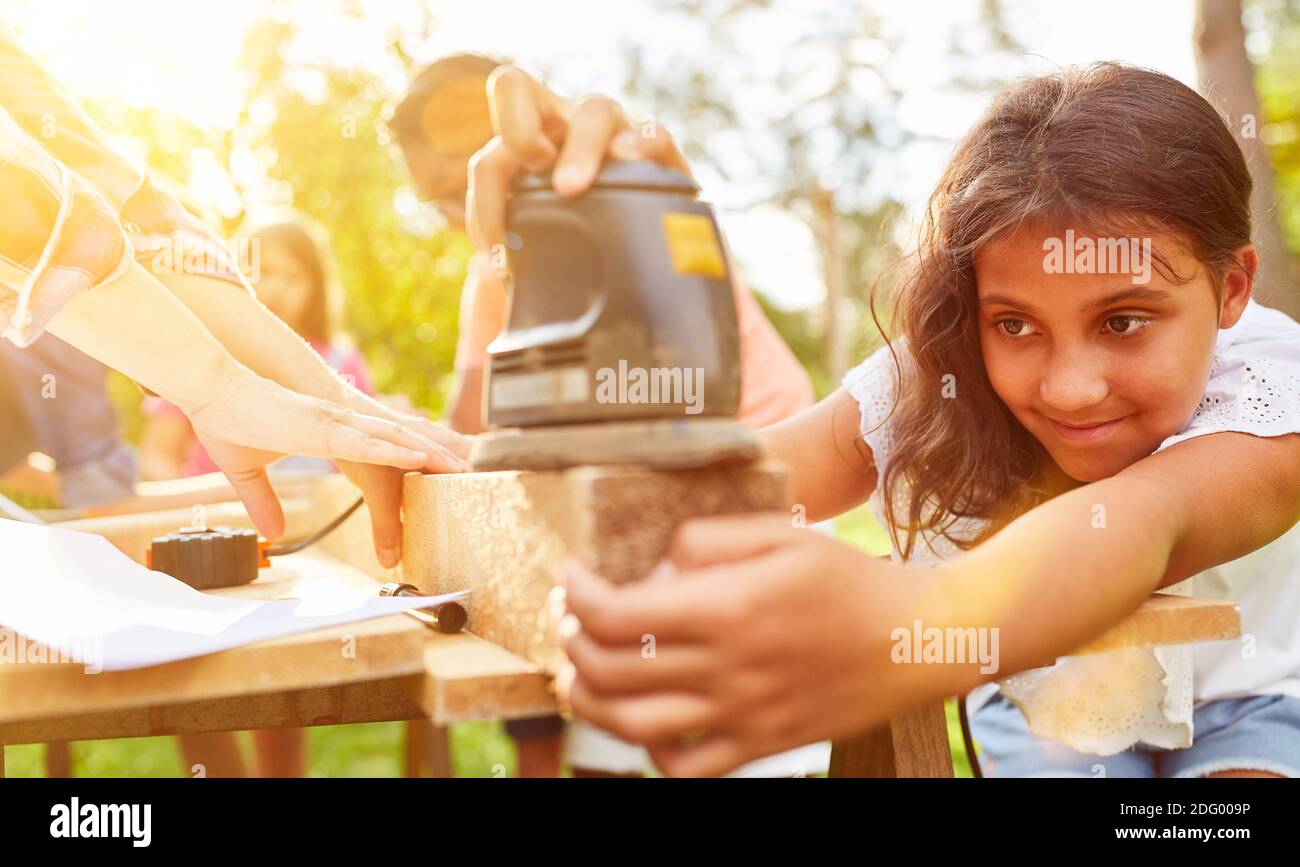 Girl sanding wood in works workshop at summer camp Stock Photo - Alamy