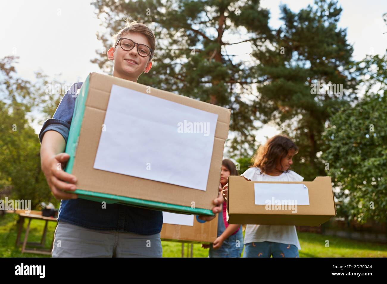 Children collect donations and old clothes in boxes during a relief ...