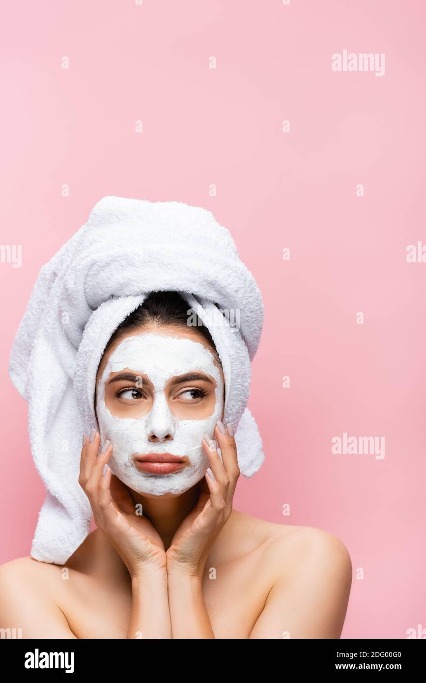 sad beautiful woman with towel on head and clay mask on face isolated ...