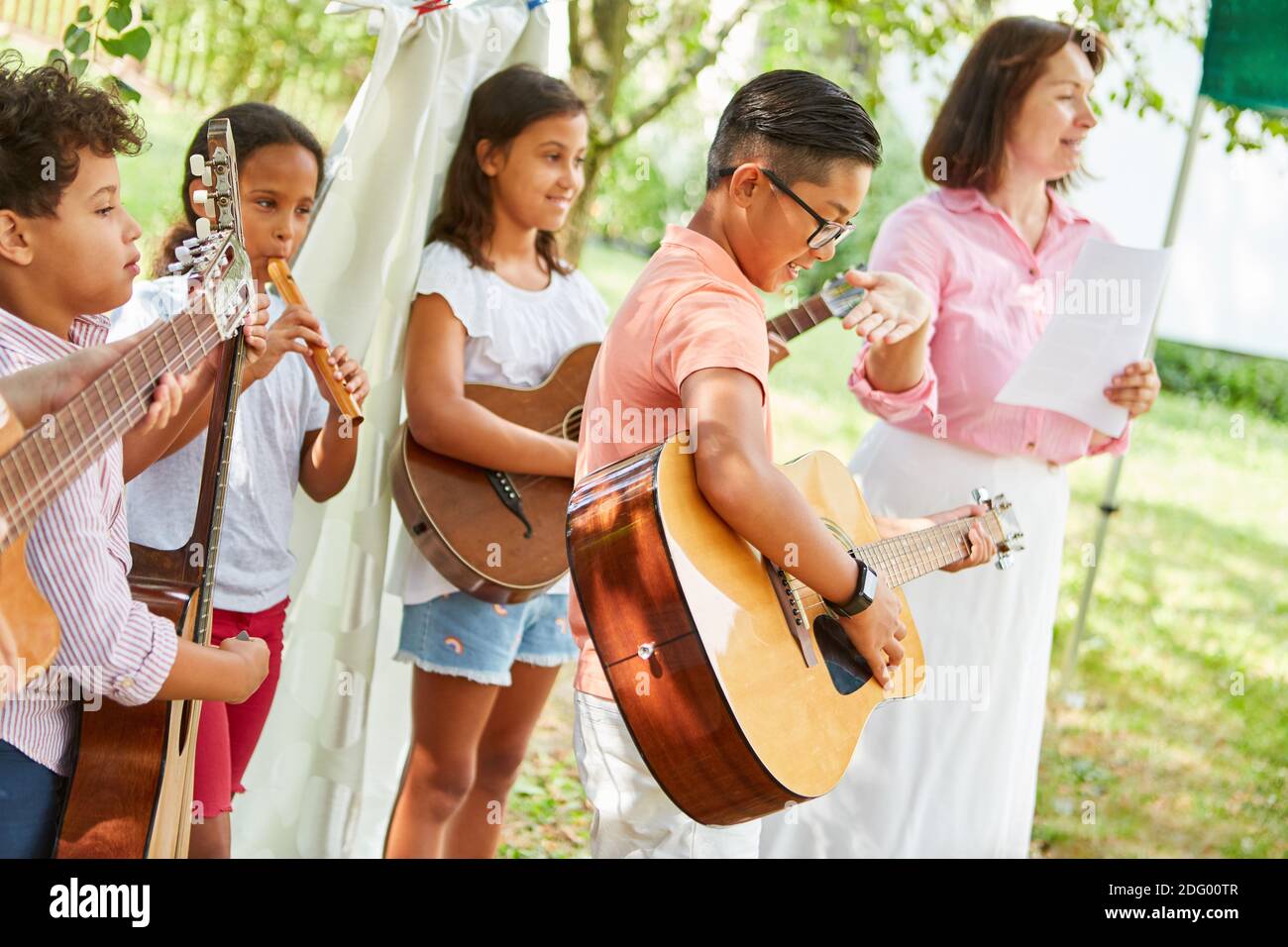 Multicultural group of children with guitars at talent show performance ...