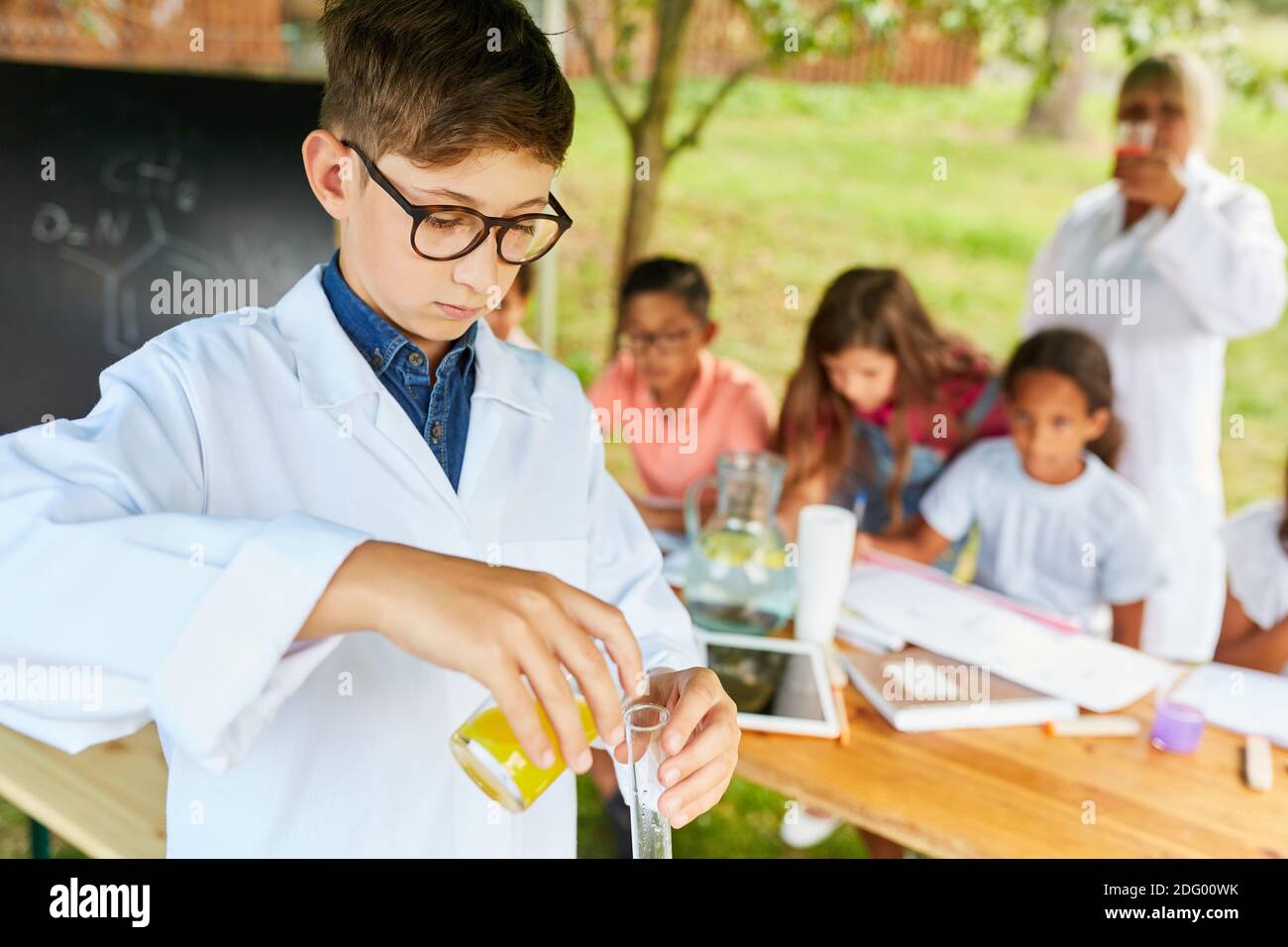 Boy doing an experiment with test tube in summer chemistry tutoring ...