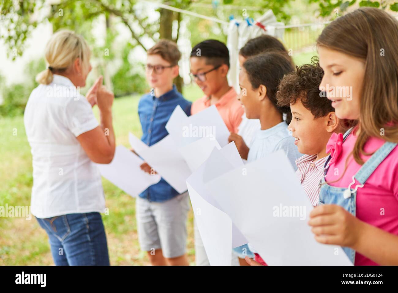 Teacher practices singing with the children's choir in the summer camp ...