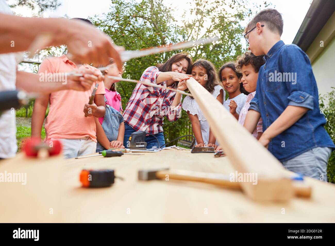 Group of children work with wood under supervision in the workshop at ...