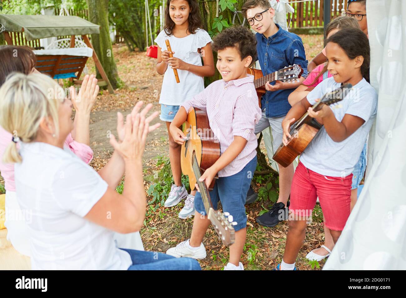 Group of children at talent show performance as a band with guitars at ...