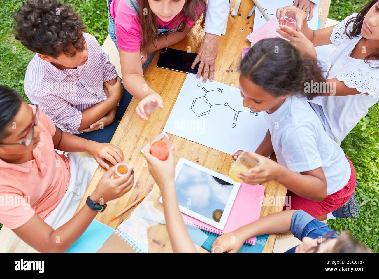 Group of multicultural children doing an experiment in a summer tuition ...