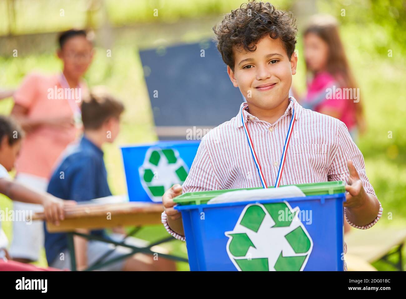 Boy carries box with recycling symbol as a volunteer environmentalist ...
