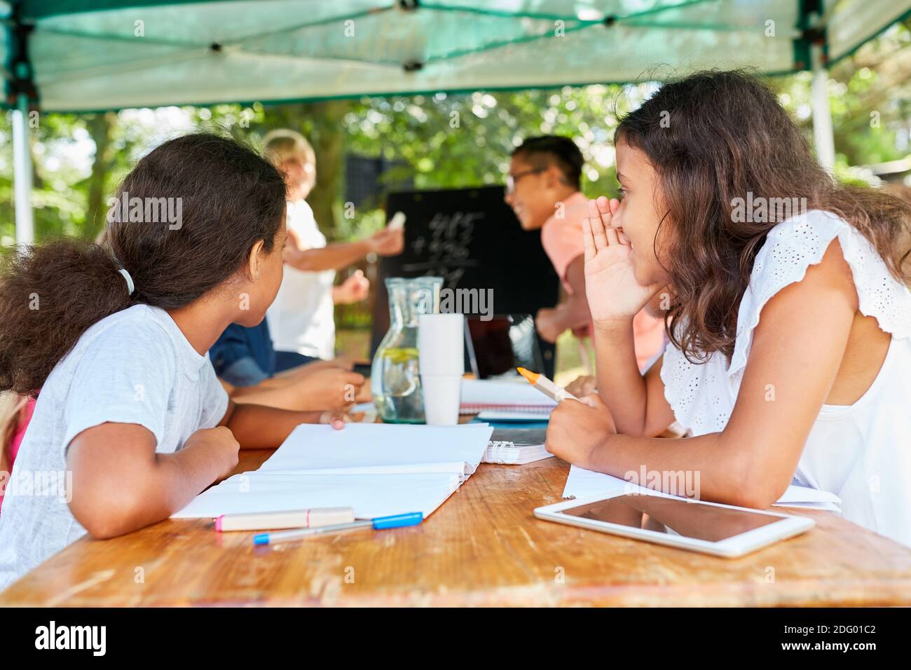 Two girls as friends in tutoring lessons in the summer school vacation ...