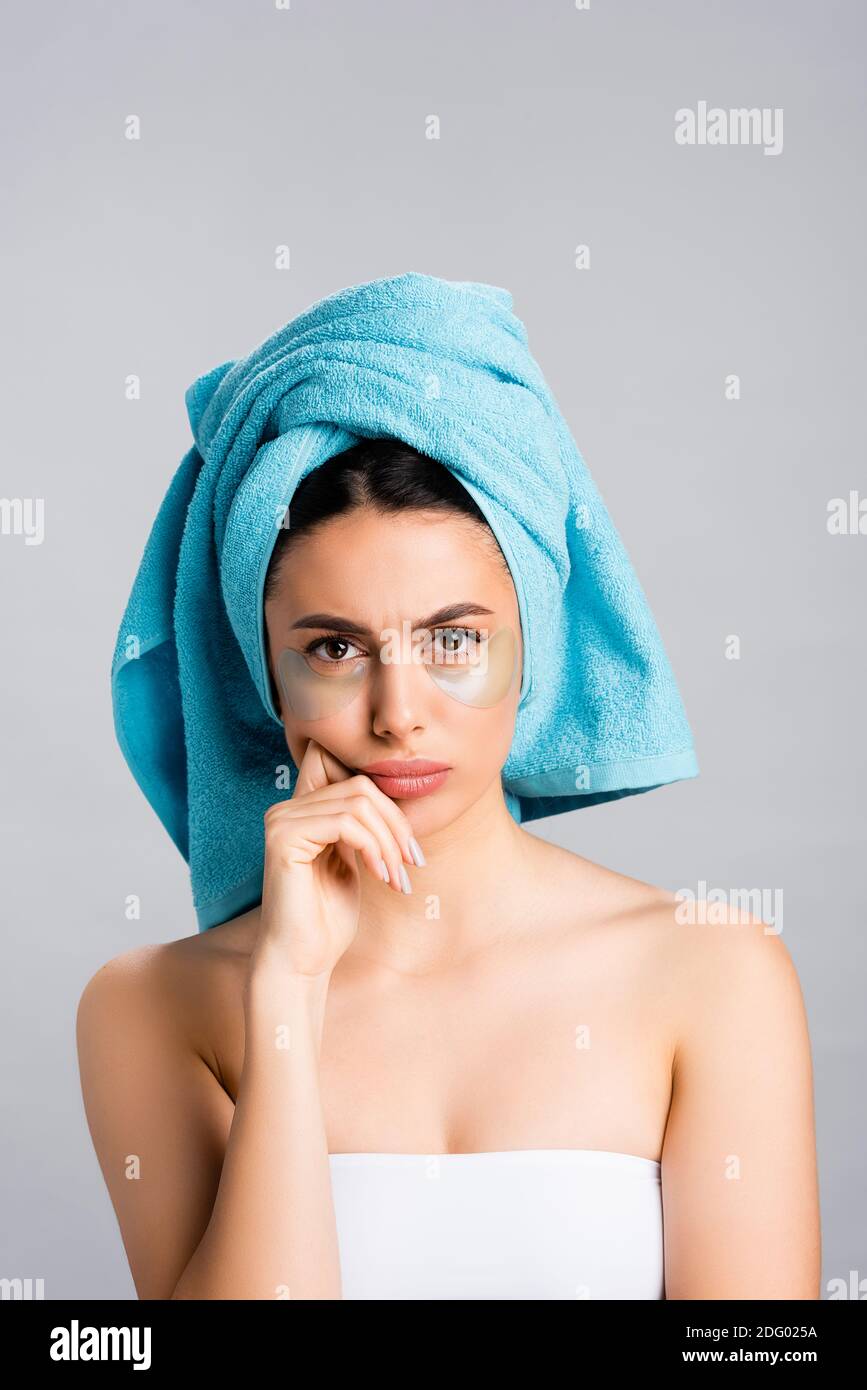 sad beautiful woman with blue towel on hair and hydrogel eye patches on ...