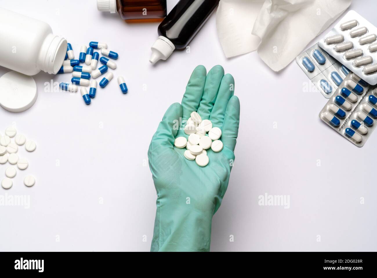 close up doctor hand in a latex glove holding tablets over light grey ...