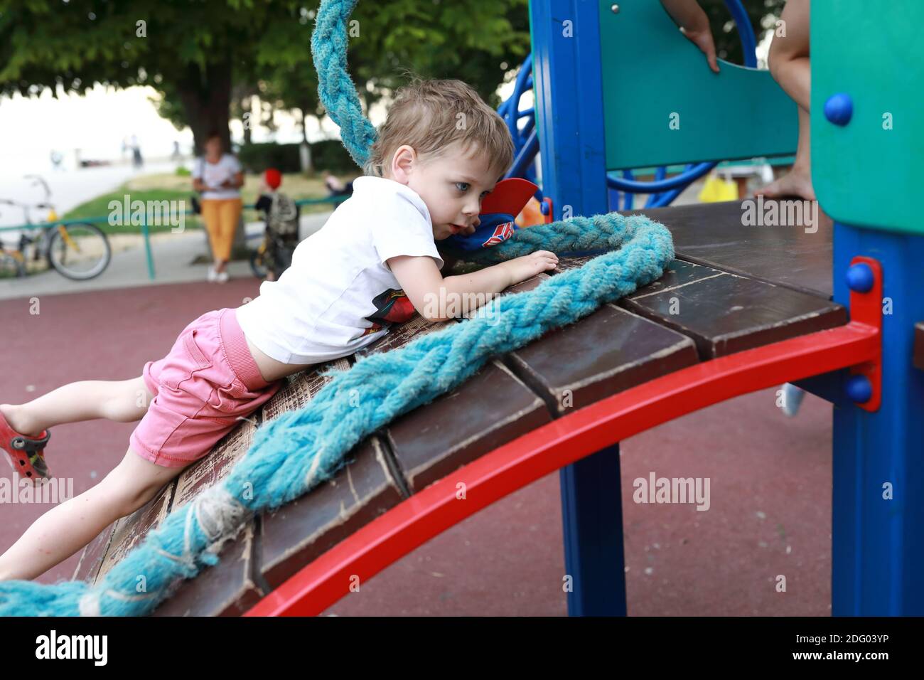 Child goes down rope at outdoor playground Stock Photo - Alamy