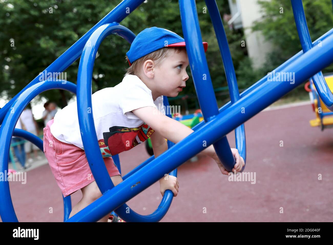 Child climbing metal bridge at playground in spring Stock Photo - Alamy