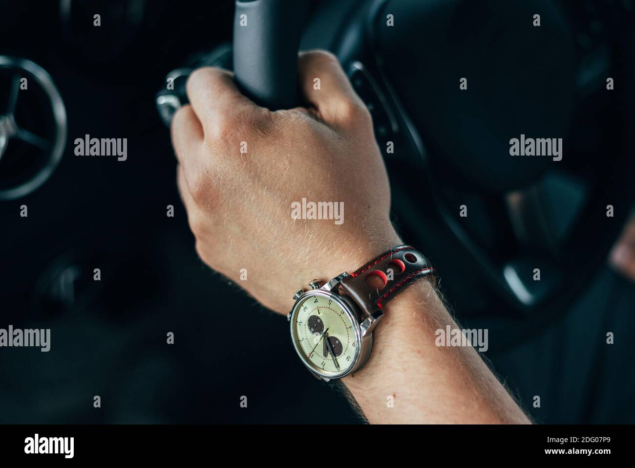 male hand with a clock holds the steering wheel of a car Stock Photo ...
