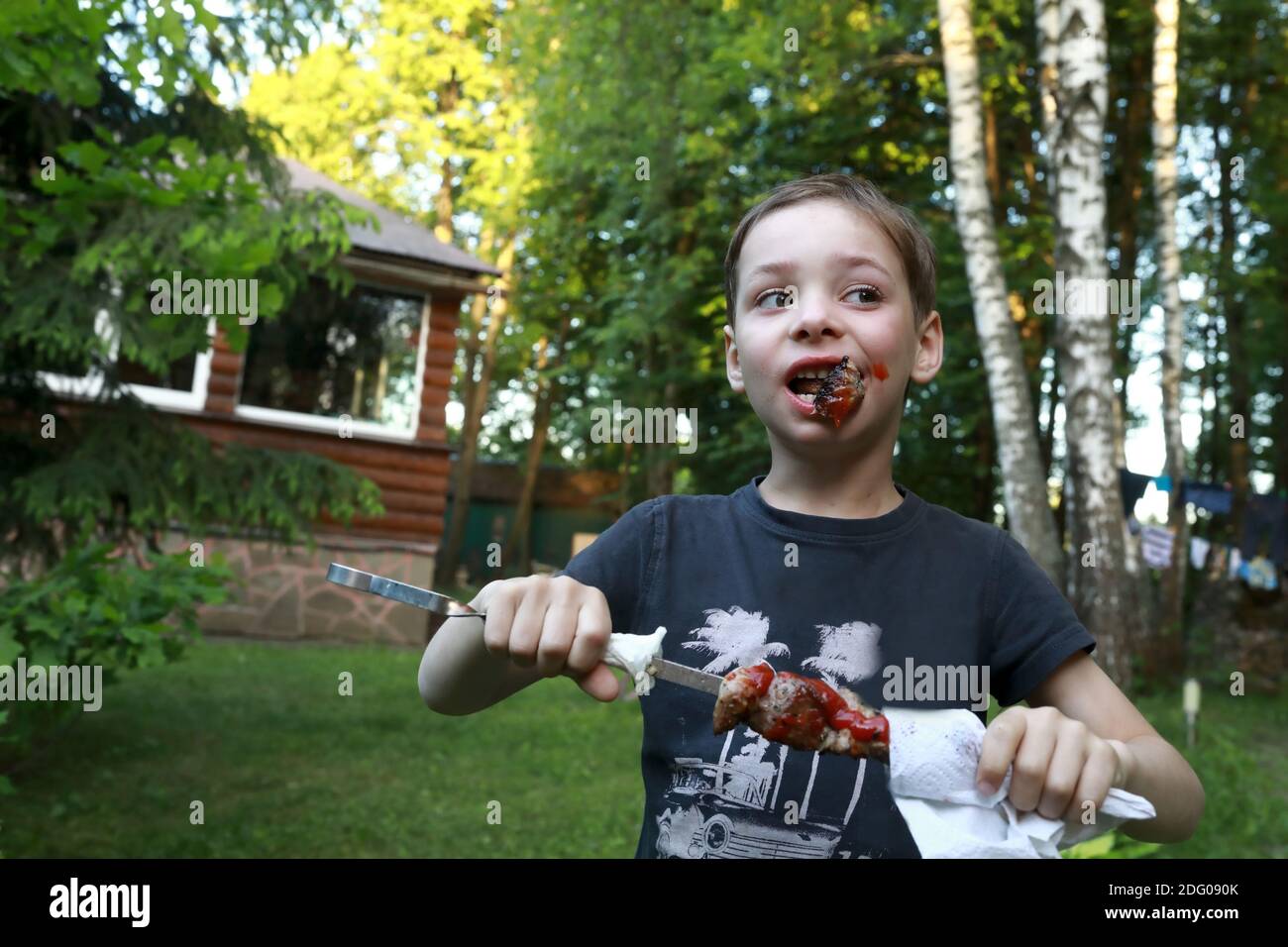Boy eating kebab at backyard in summer Stock Photo - Alamy