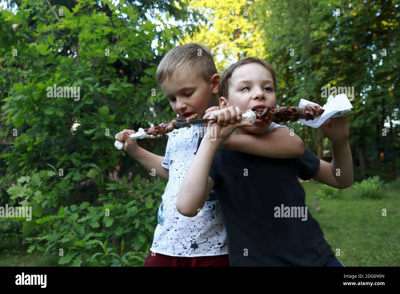 Brothers eating kebab at backyard in summer Stock Photo - Alamy