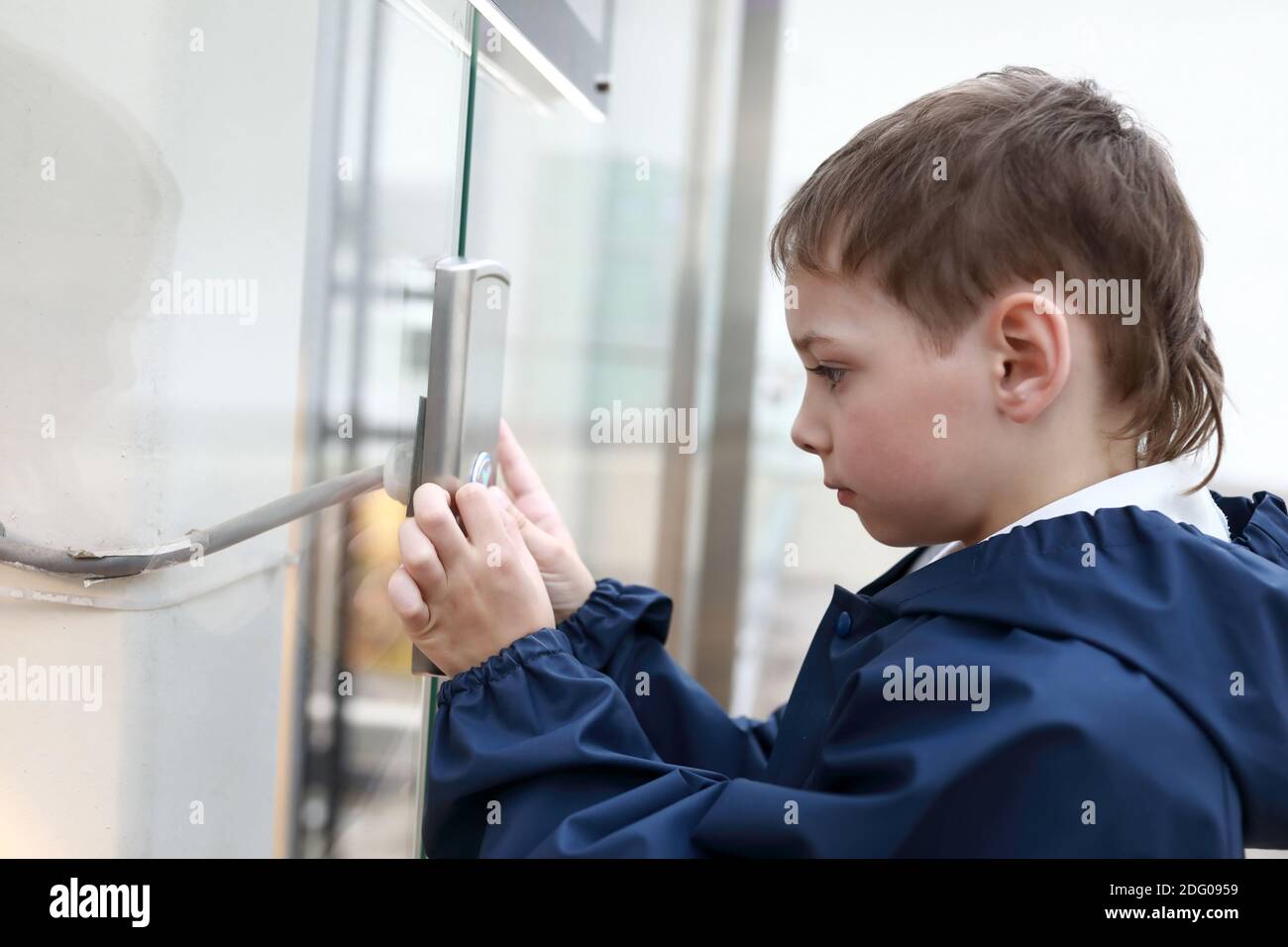Portrait of a boy calling the elevator Stock Photo - Alamy