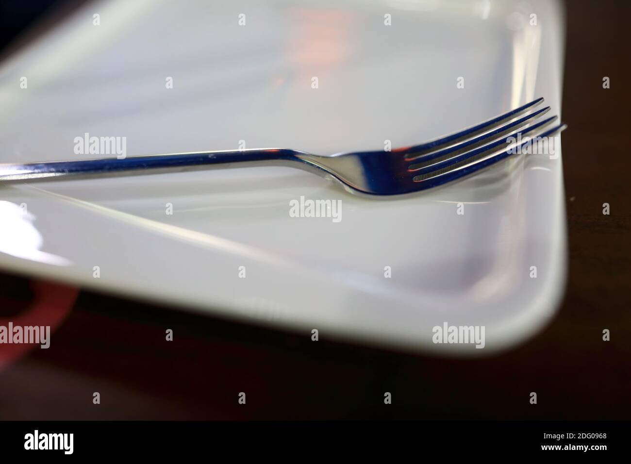 Details of fork on plate in cafe Stock Photo - Alamy