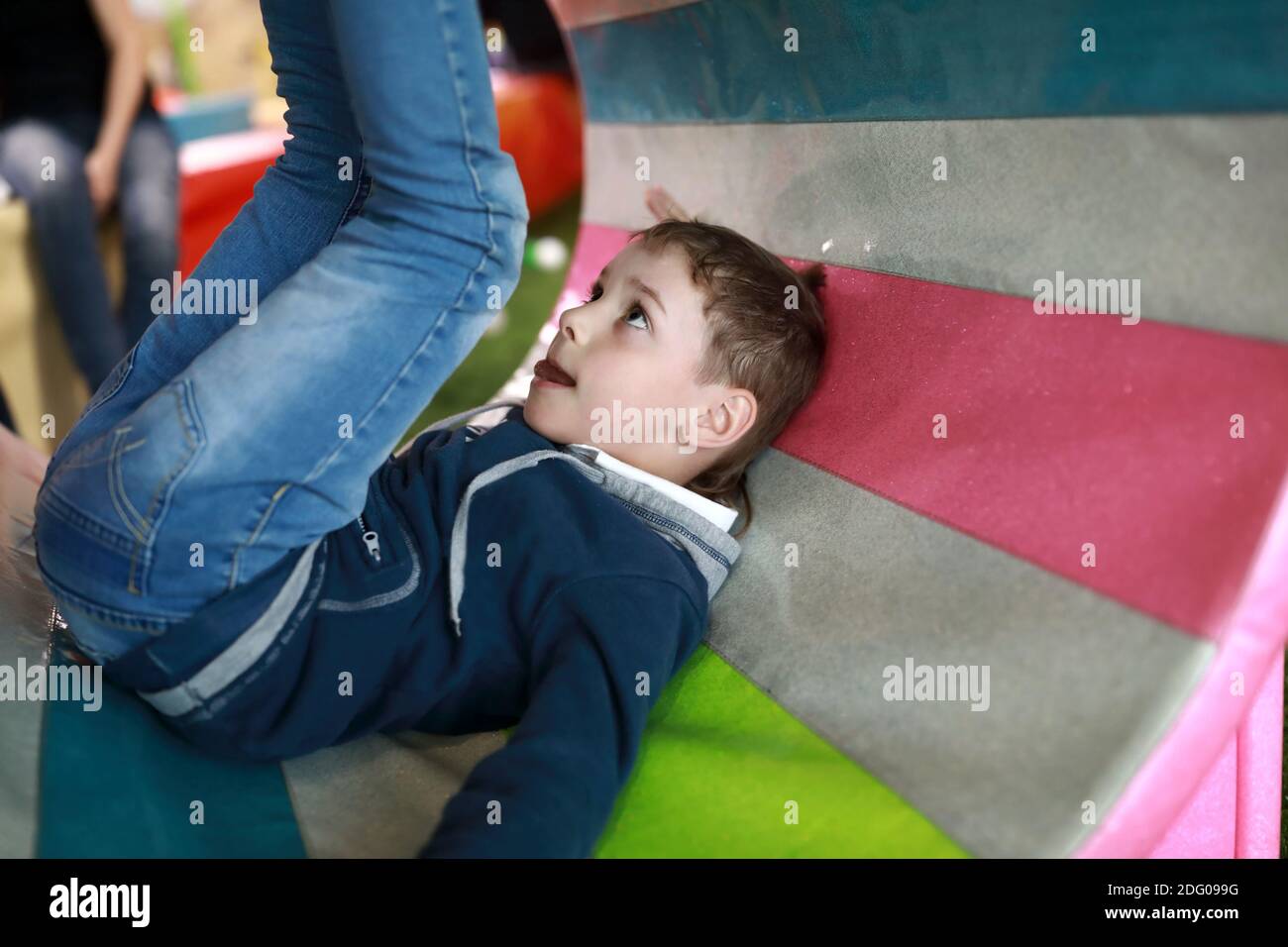 Kid turns inside rotating cylinder at playground Stock Photo - Alamy