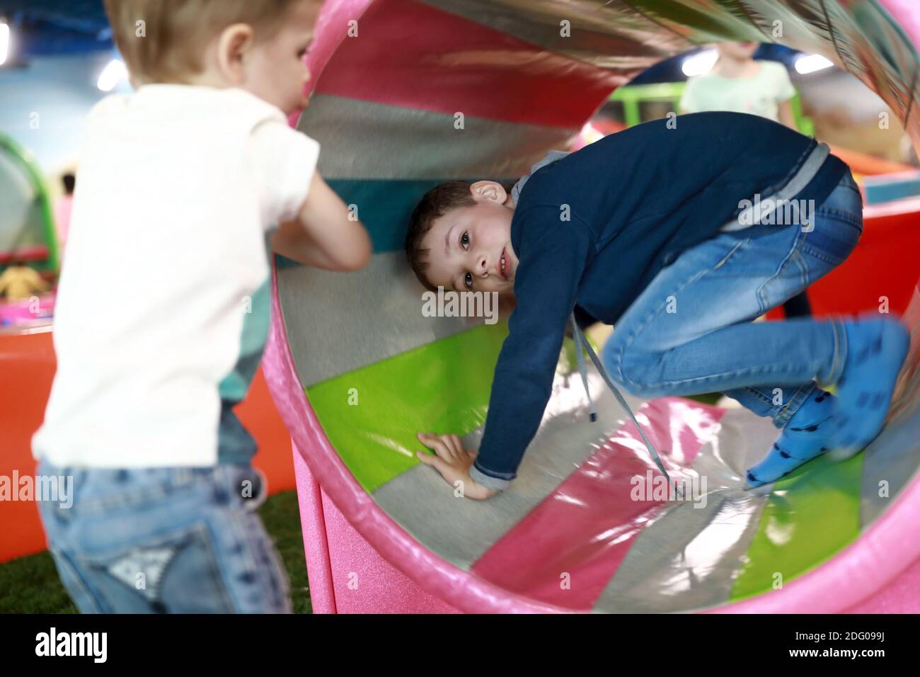 Boy turns inside rotating cylinder at playground Stock Photo - Alamy