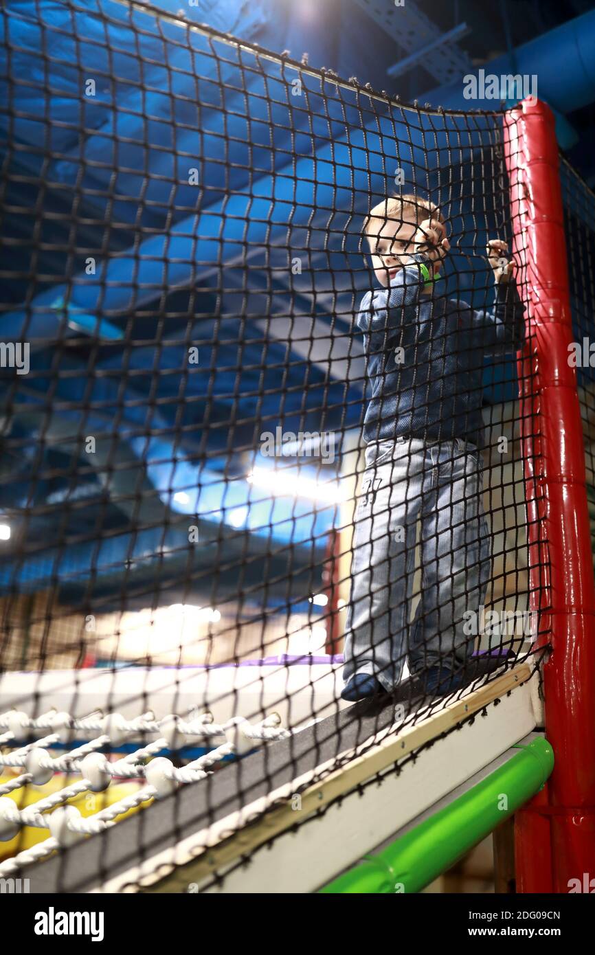 Child holding on to rope mesh at playground Stock Photo - Alamy