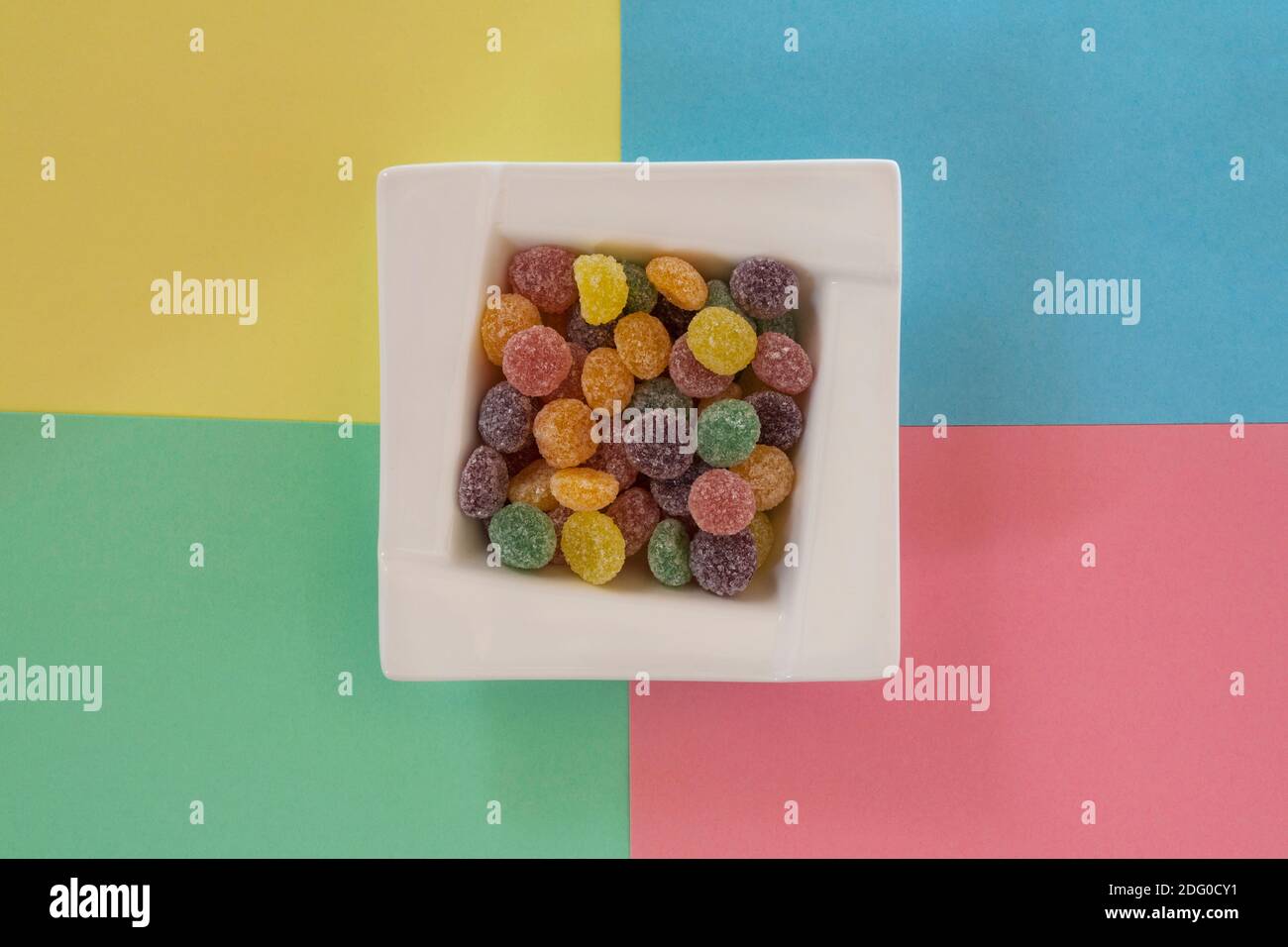 Rowntrees Jelly Tots sweets in bowl on pastel yellow, pink blue and ...
