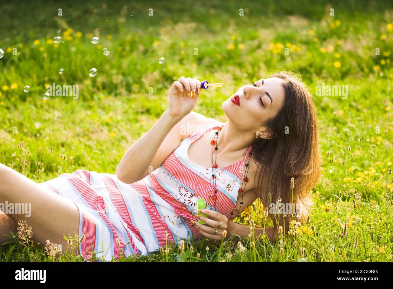 Girl inflating soap-bubbles in field Stock Photo - Alamy
