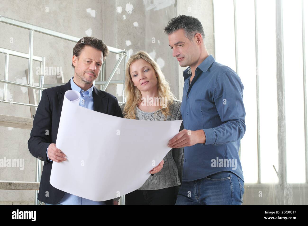 Architect showing house design plans to a young couple. House building ...