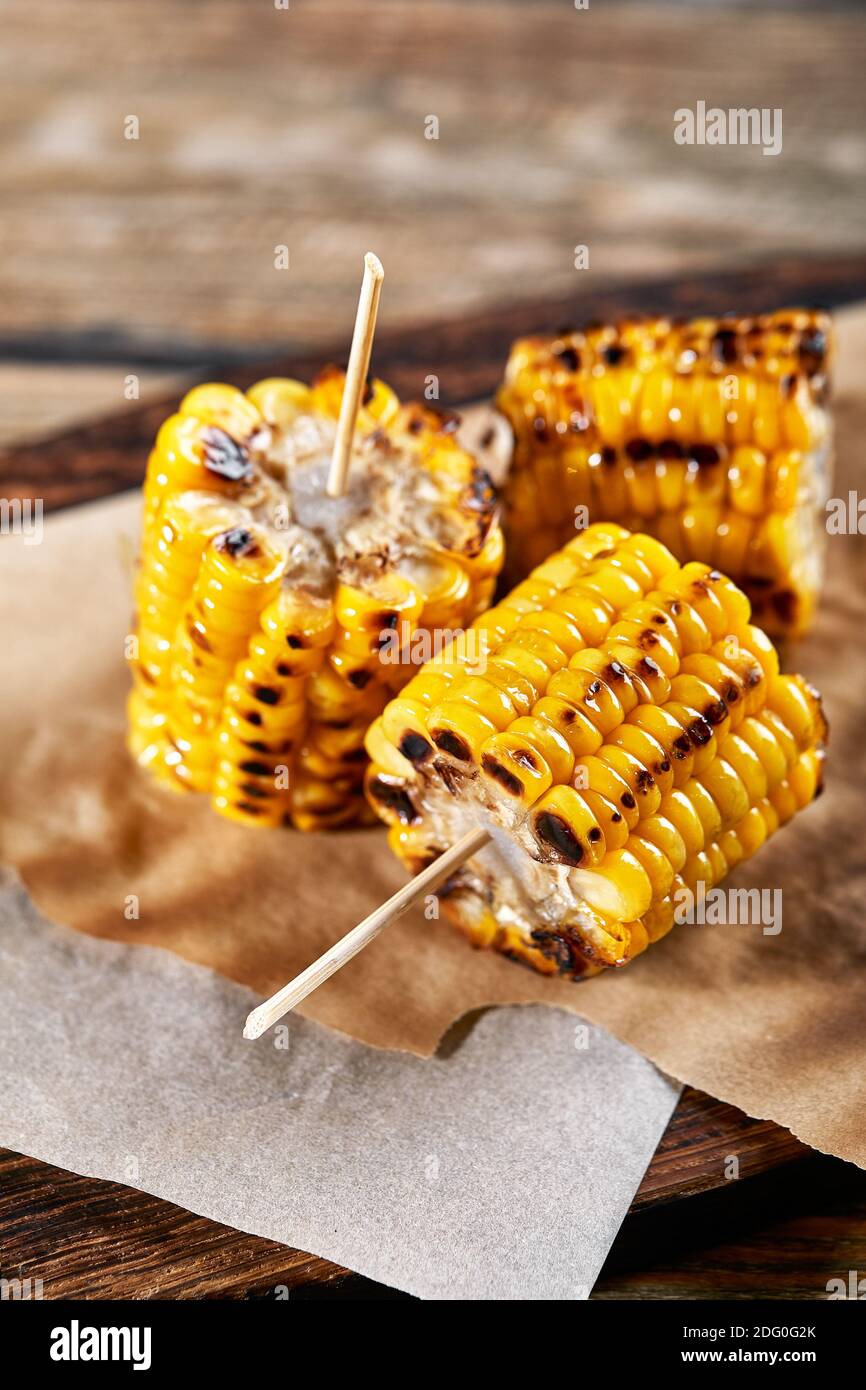Corn grilled with salt and spices. Dark background. Fast food in the ...