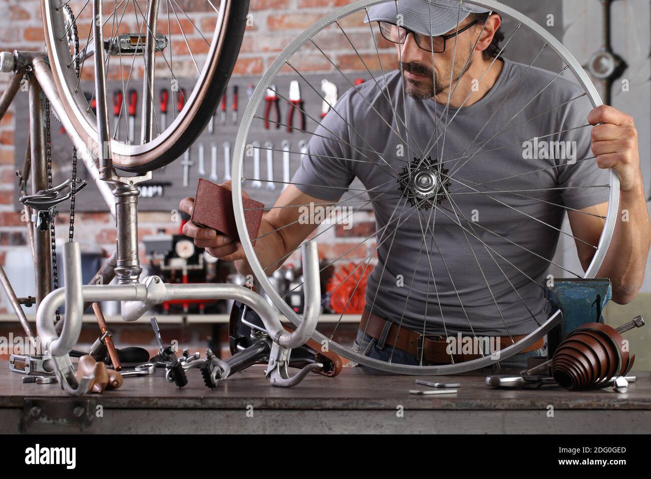 man repair the vintage bicycle in garage workshop on the workbench with ...