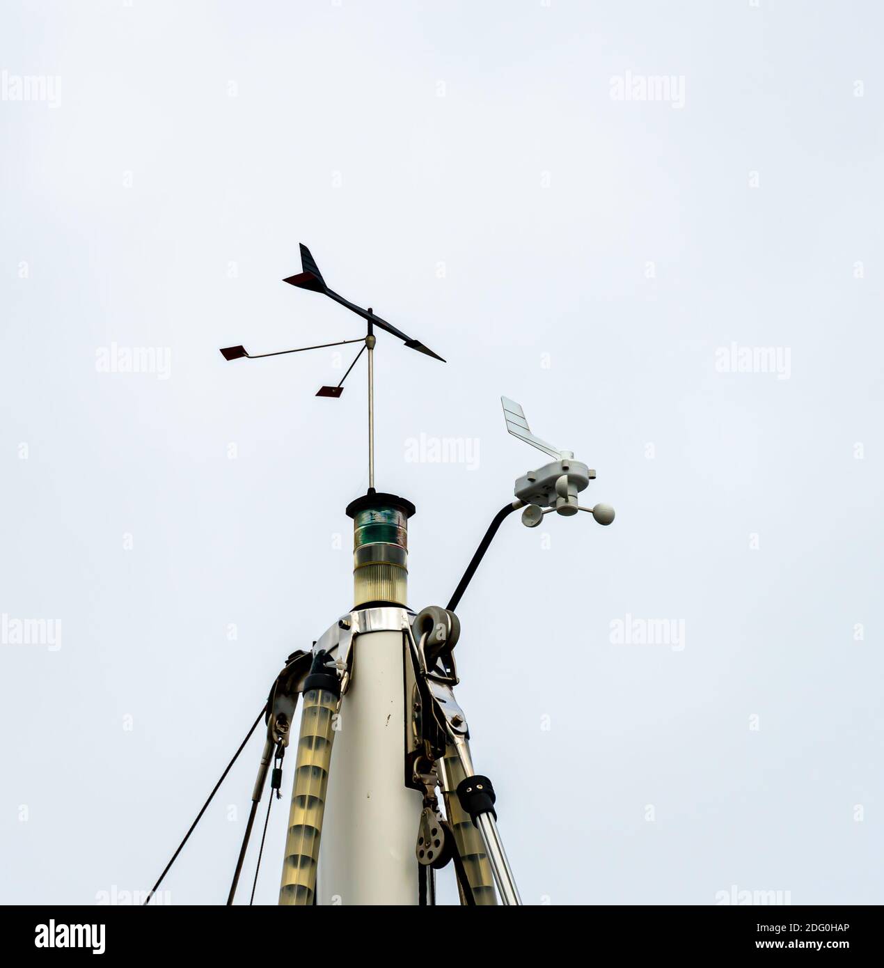 Top of the mast of a sailboat with wind indicator, lanterns, antennas ...