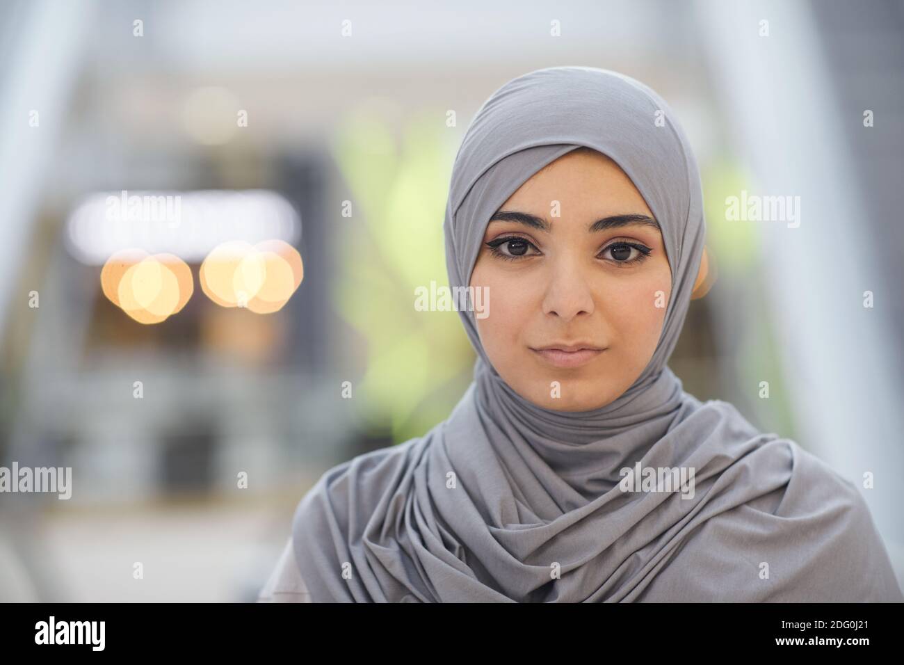 Close up portrait of beautiful Middle-Eastern woman wearing grey ...