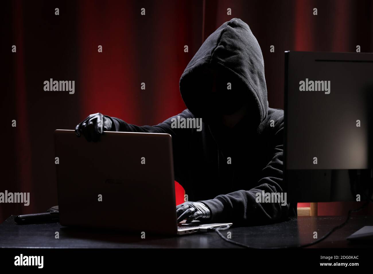 International hacker in black pullover and black mask trying to hack ...