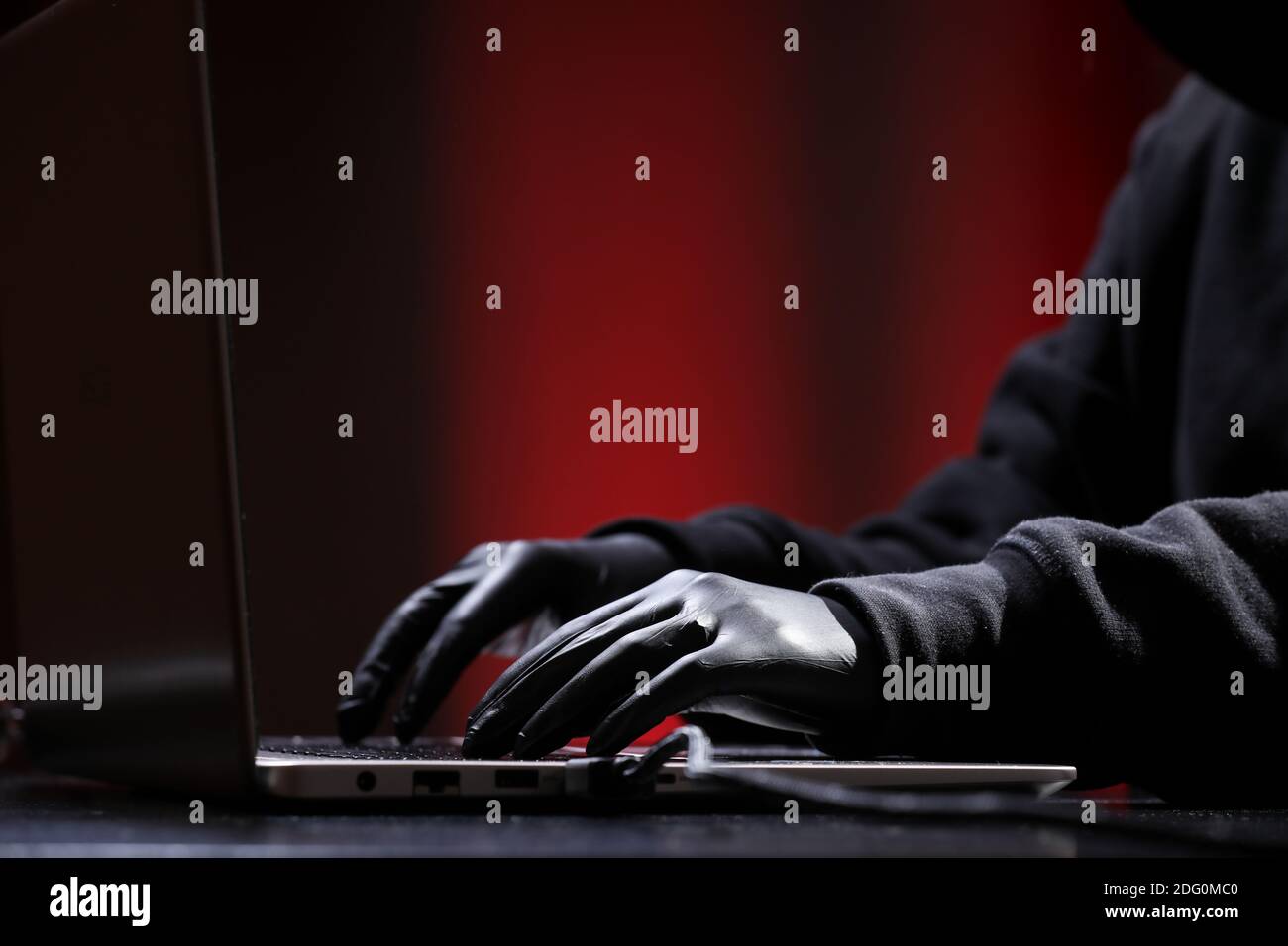 International hacker in black pullover and black mask trying to hack ...