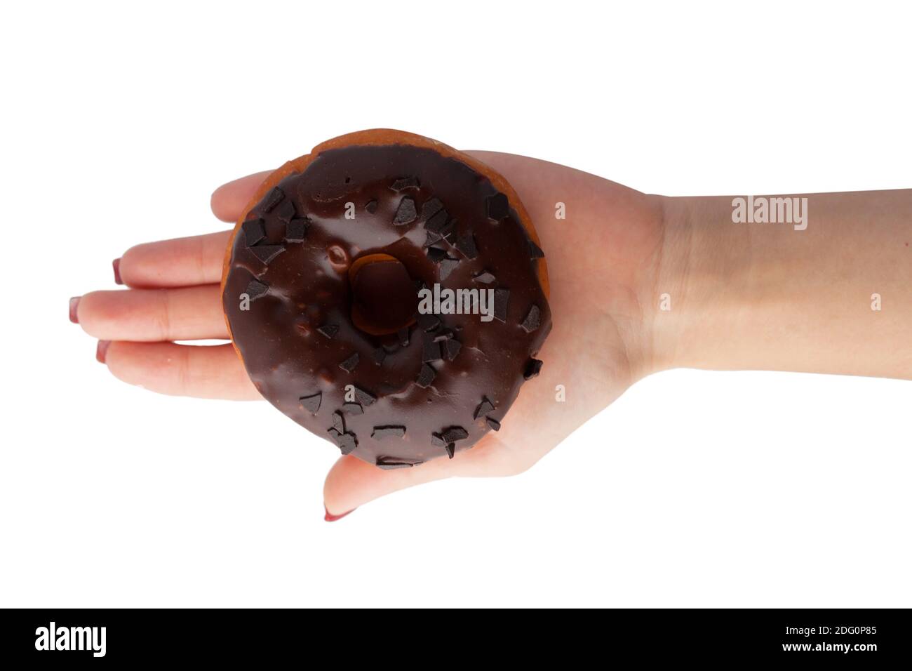Female hand holds with fingers a chocolate brown donut in glaze ...