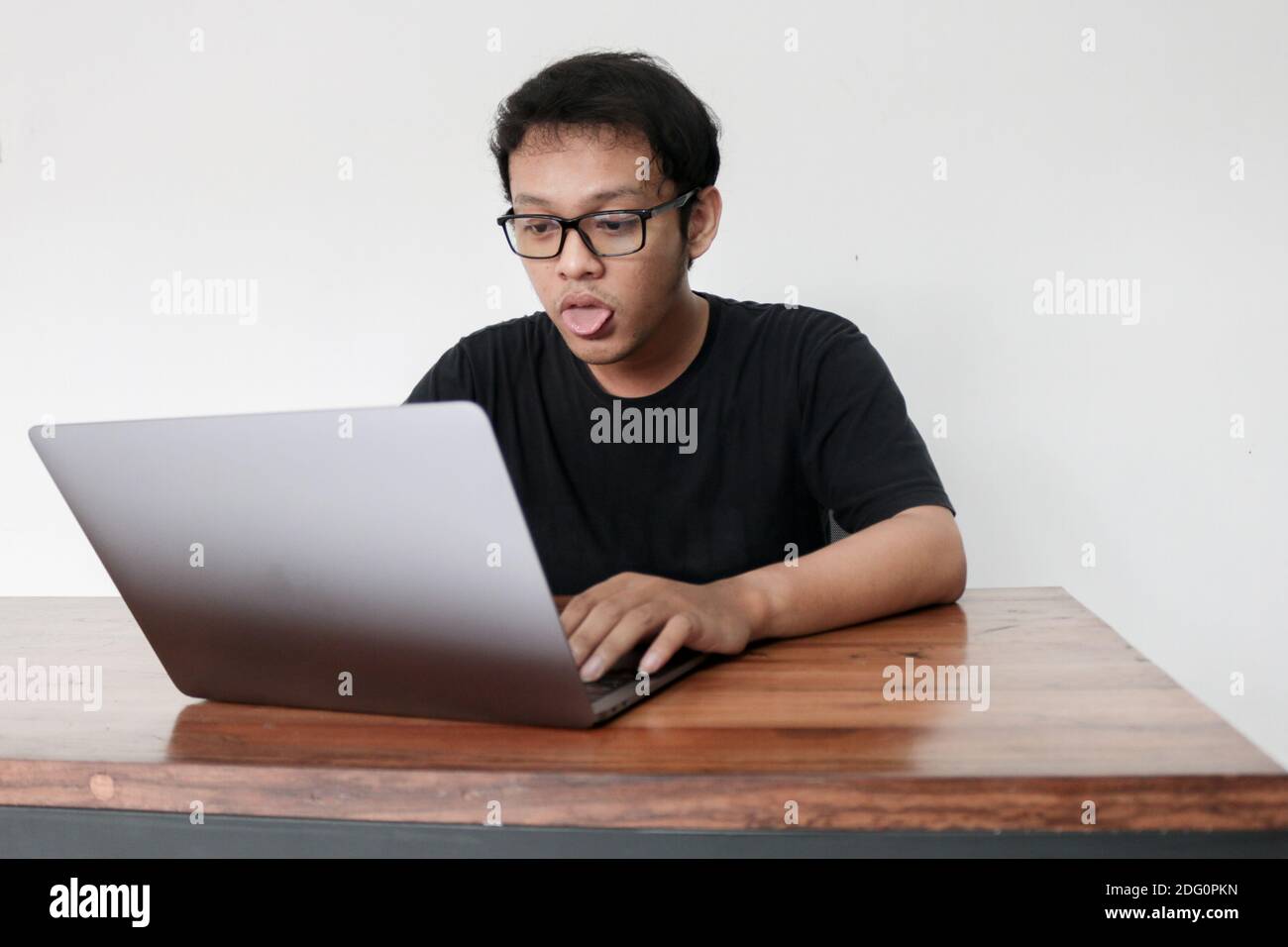 Young Asian man is boring and lazy in the front the laptop. Indonesia ...