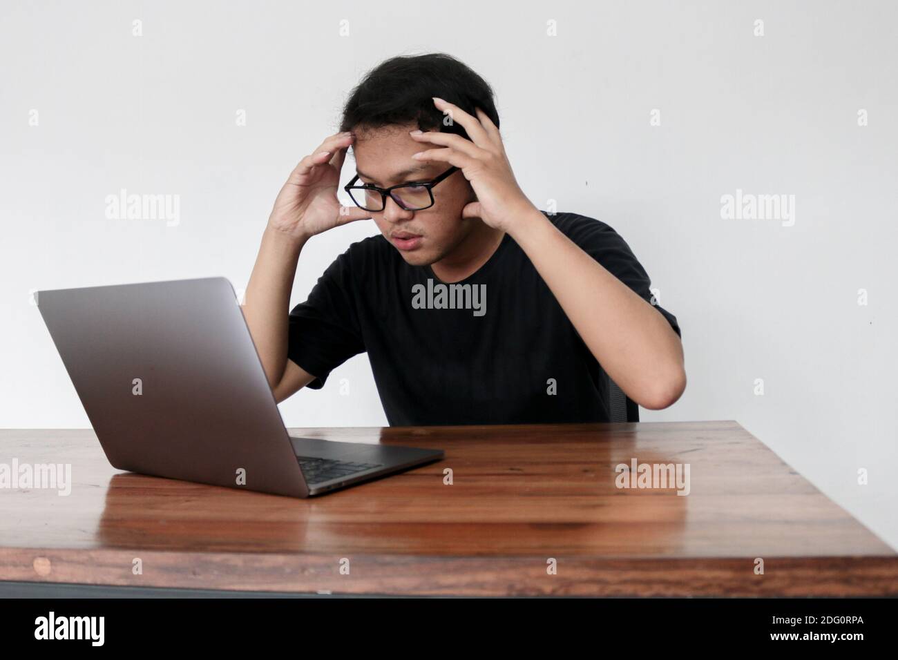 Young Asian man is boring and lazy in the front the laptop. Indonesia ...