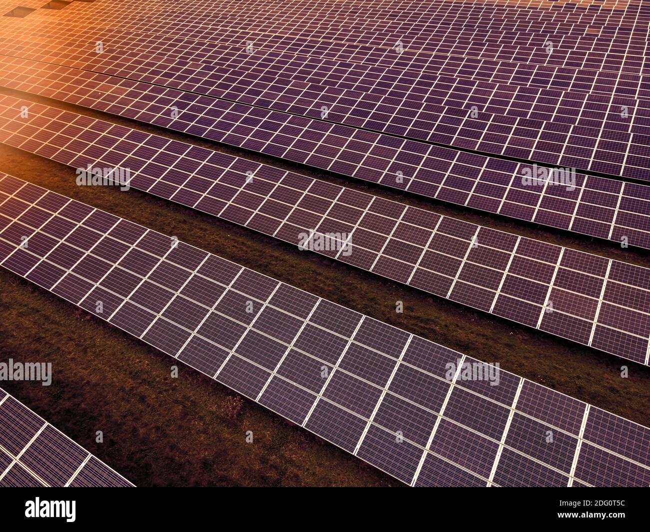 Large solar farm at sunset, with rows of modern panels collecting ...