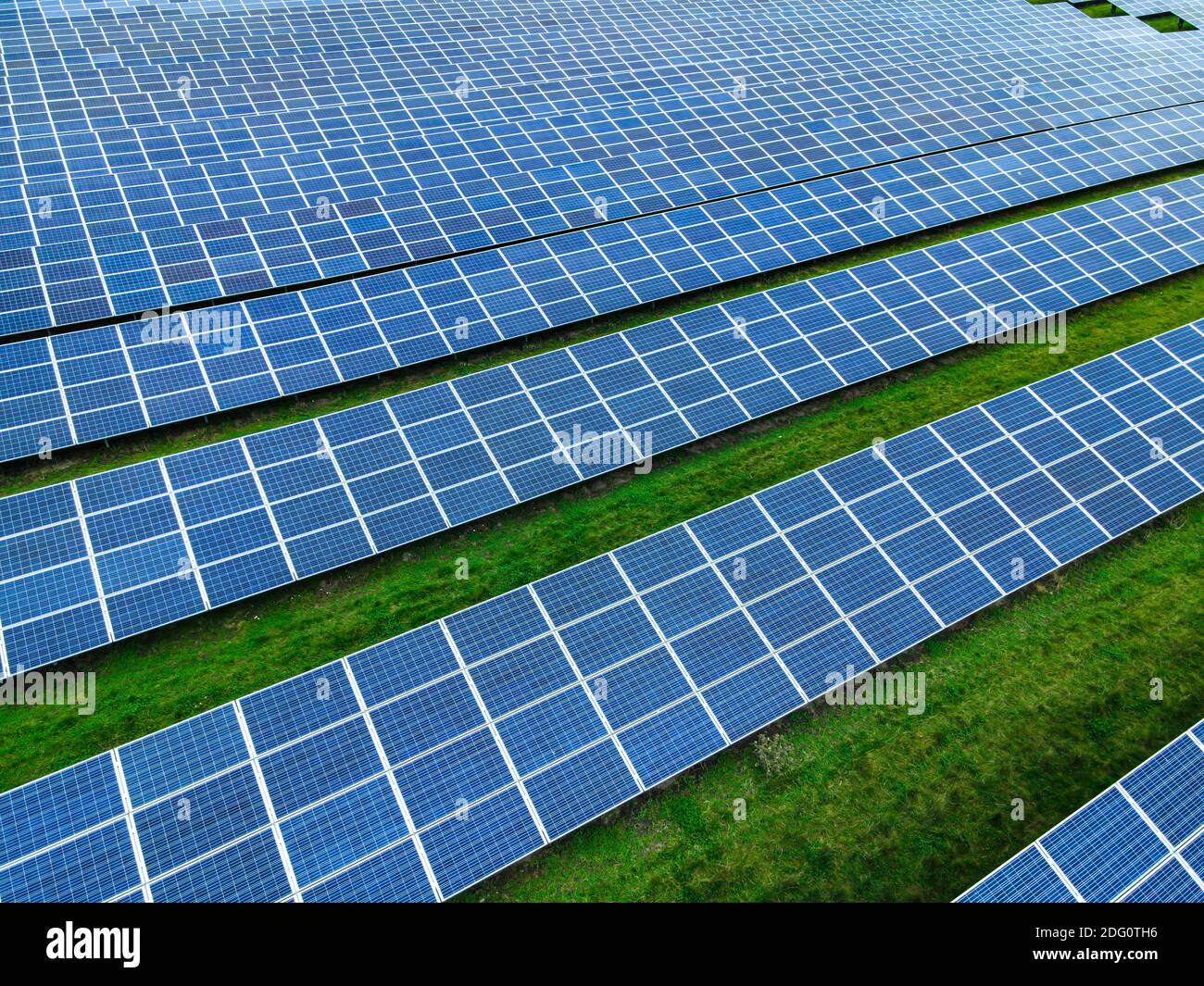 Solar power farm on a grass field with rows of modern panels collecting ...
