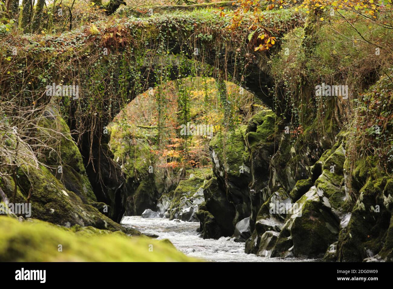 Autumn scene on the River Conwy flowing beneath a pack horse bridge at ...