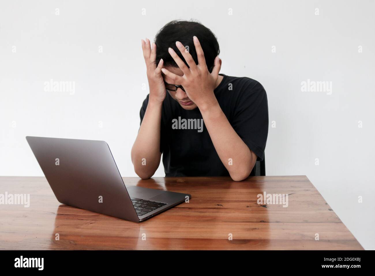 Young Asian man feeling stress and confuse with work in laptop ...