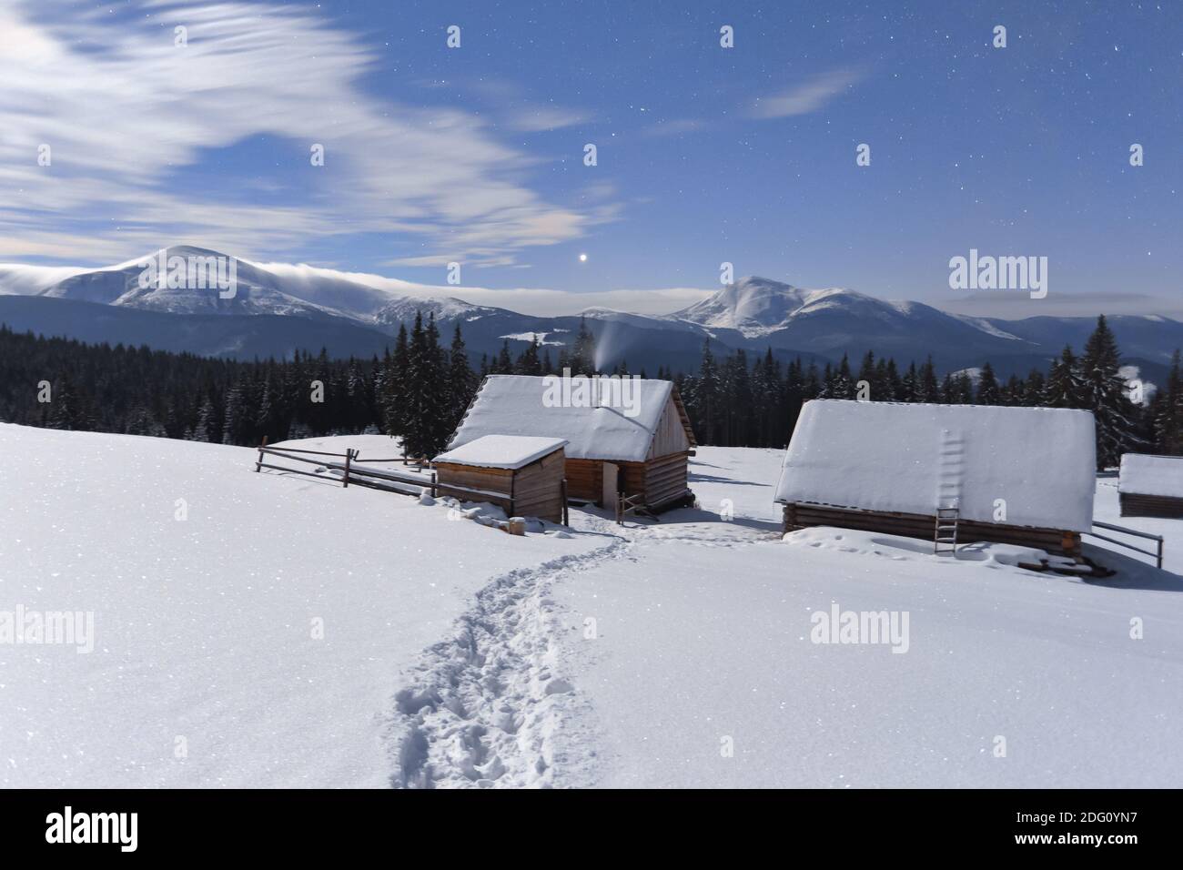 Winter scenery. Old wooden huts on the lawn covered with snow ...