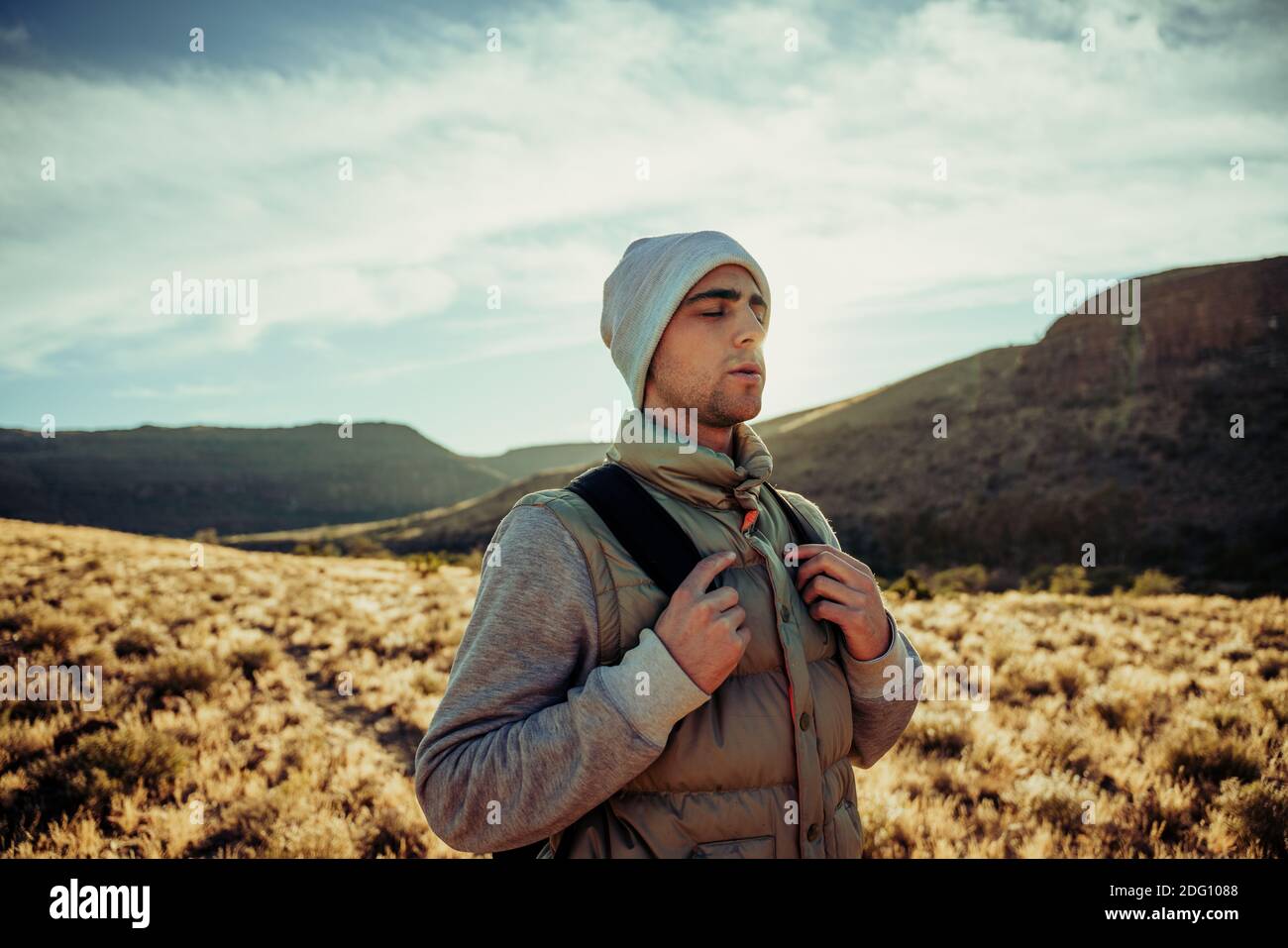 young caucasian male walking calmly through mountain while on ...