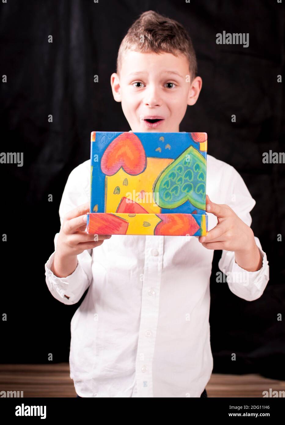 Child in white shirt with a gift in hand Stock Photo - Alamy