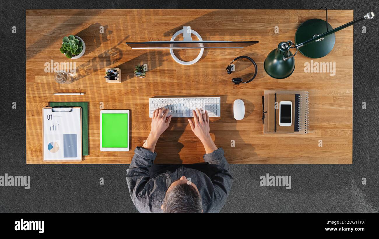 Top view of businessman working on computer at desk with keyable screen ...