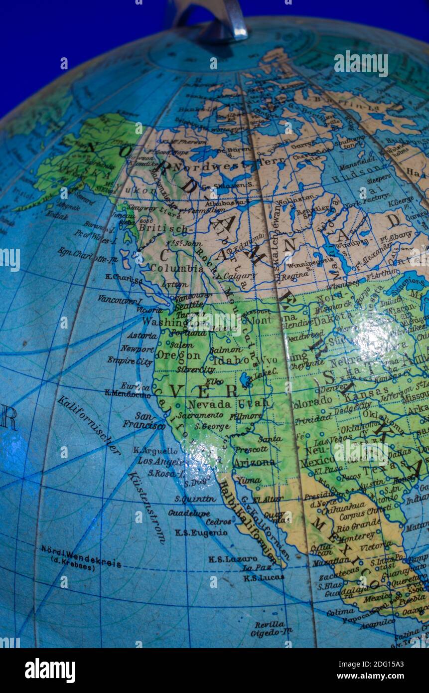 Cut globe in front of blue ground Stock Photo - Alamy